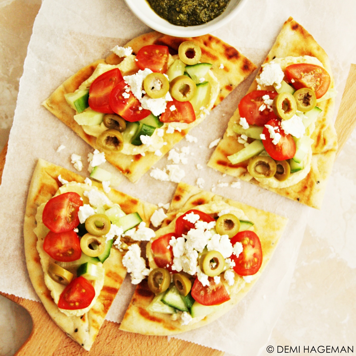 Crispy flatbread met hummus, komkommer, tomaat, feta en pesto - StudioKOOK